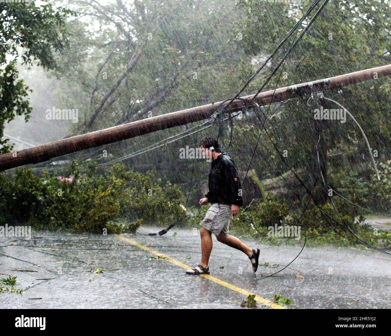 A pedestrian walks around fallen powerlines and trees in Halifax. Hurricane Juan, which was ...