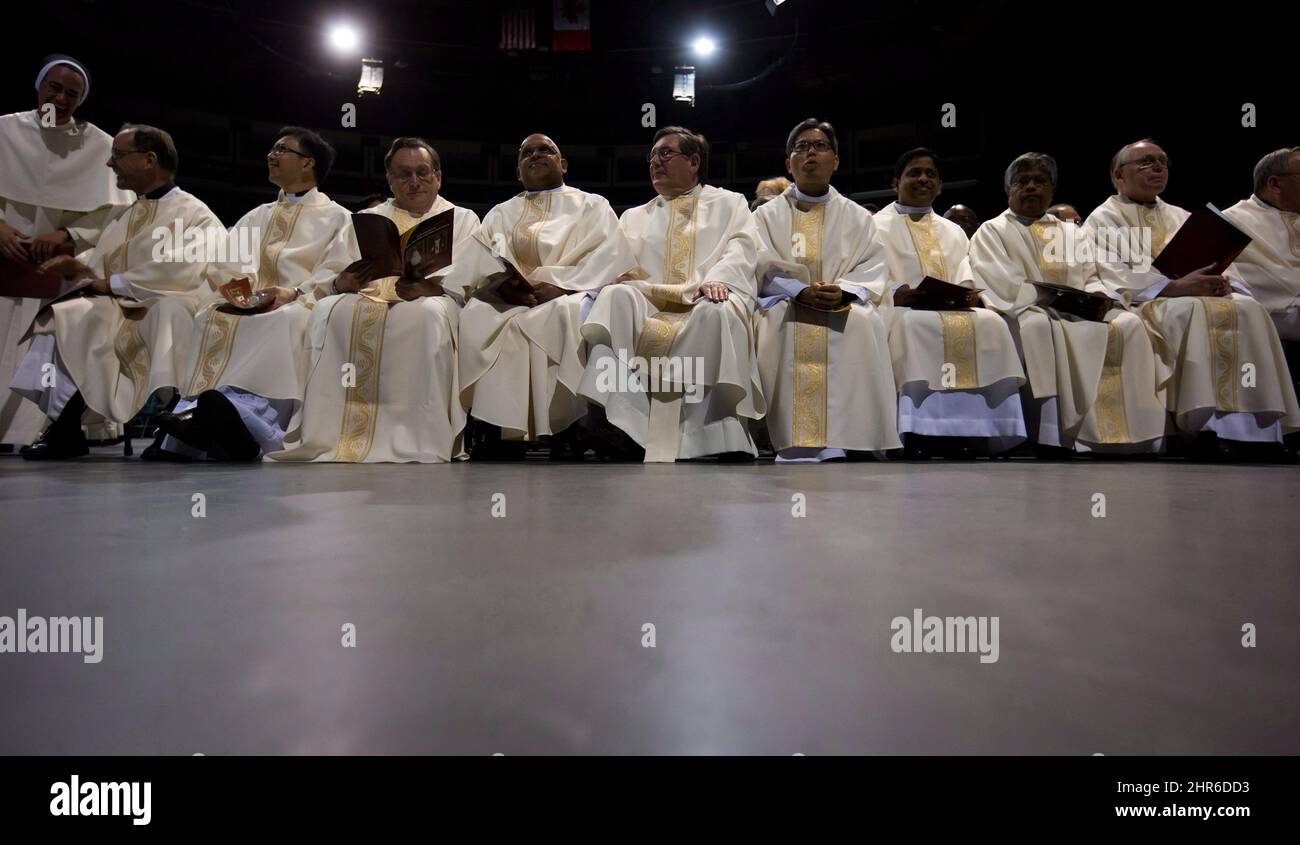 Priests sit together as thousands of Catholics gather for a special ...