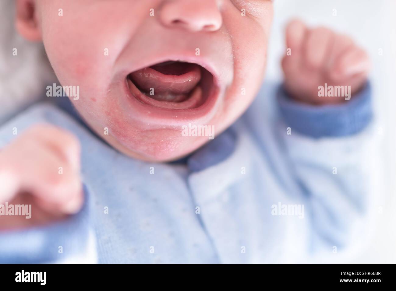 Portrait of a crying newborn. discomfort of the baby with colic in the ...