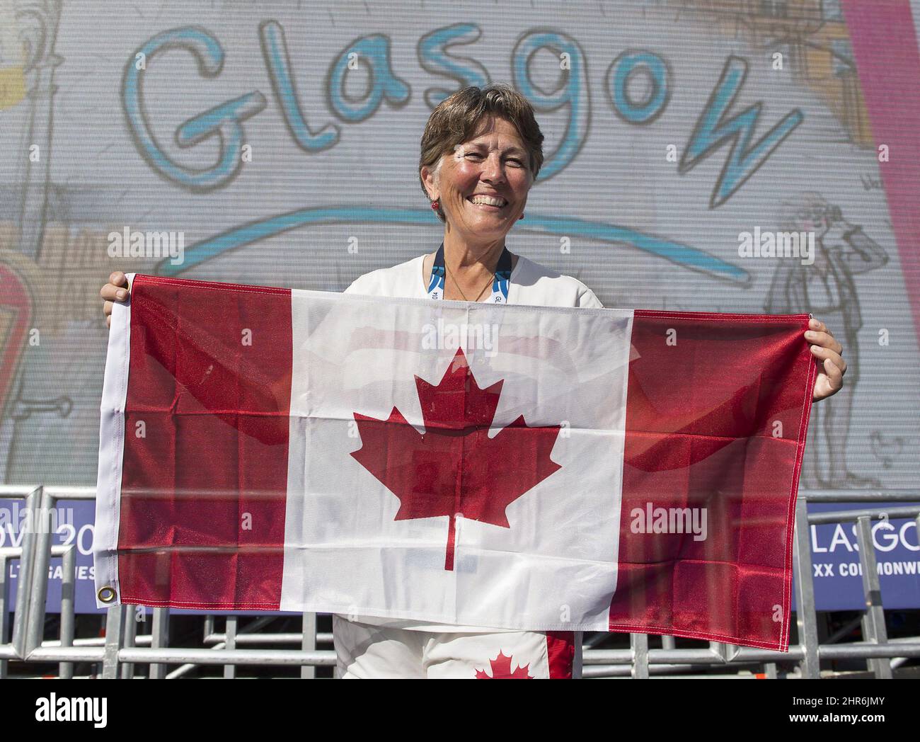 Trap shooter Susan Nattrass smiles as she displays the Canadian flag as ...