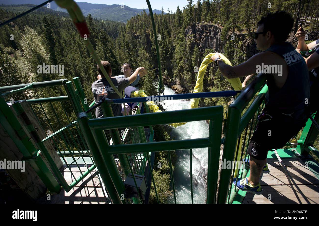 A girl prepares to jump off the bridge backwards at Whistler Bungee in ...