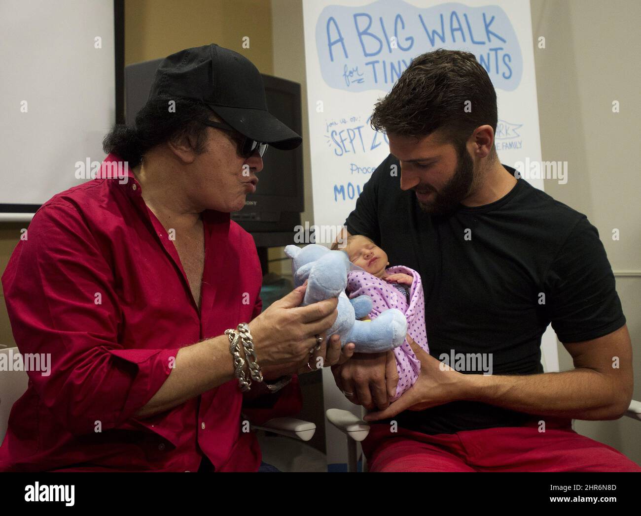KISS rock stars Gene Simmons, left, looks at baby girl Charlie Rose ...