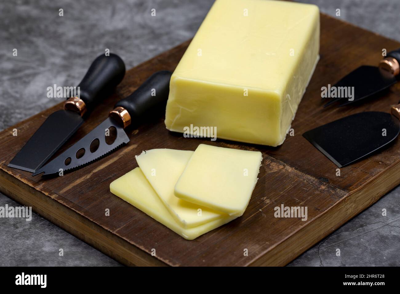 Kashar cheese or kashkaval cheese on dark background. Sliced Cheddar ...