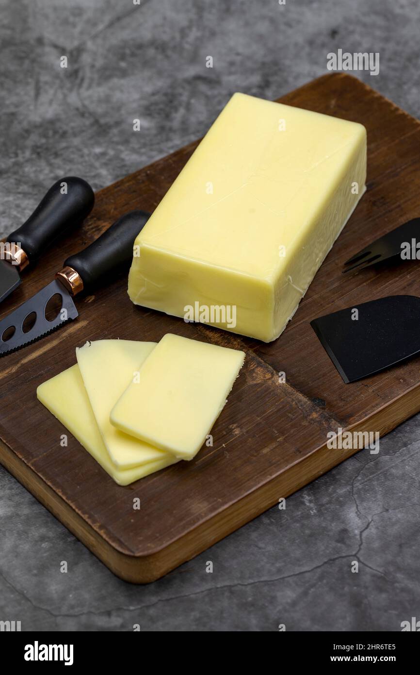 Kashar cheese or kashkaval cheese on dark background. Sliced Cheddar ...