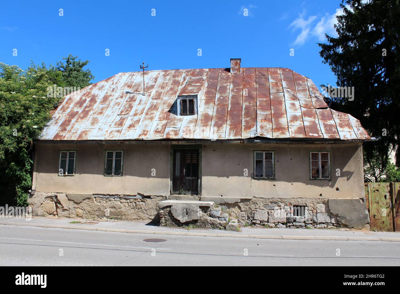 Front view of abandoned small urban family house on broken stone and concrete foundation with ...