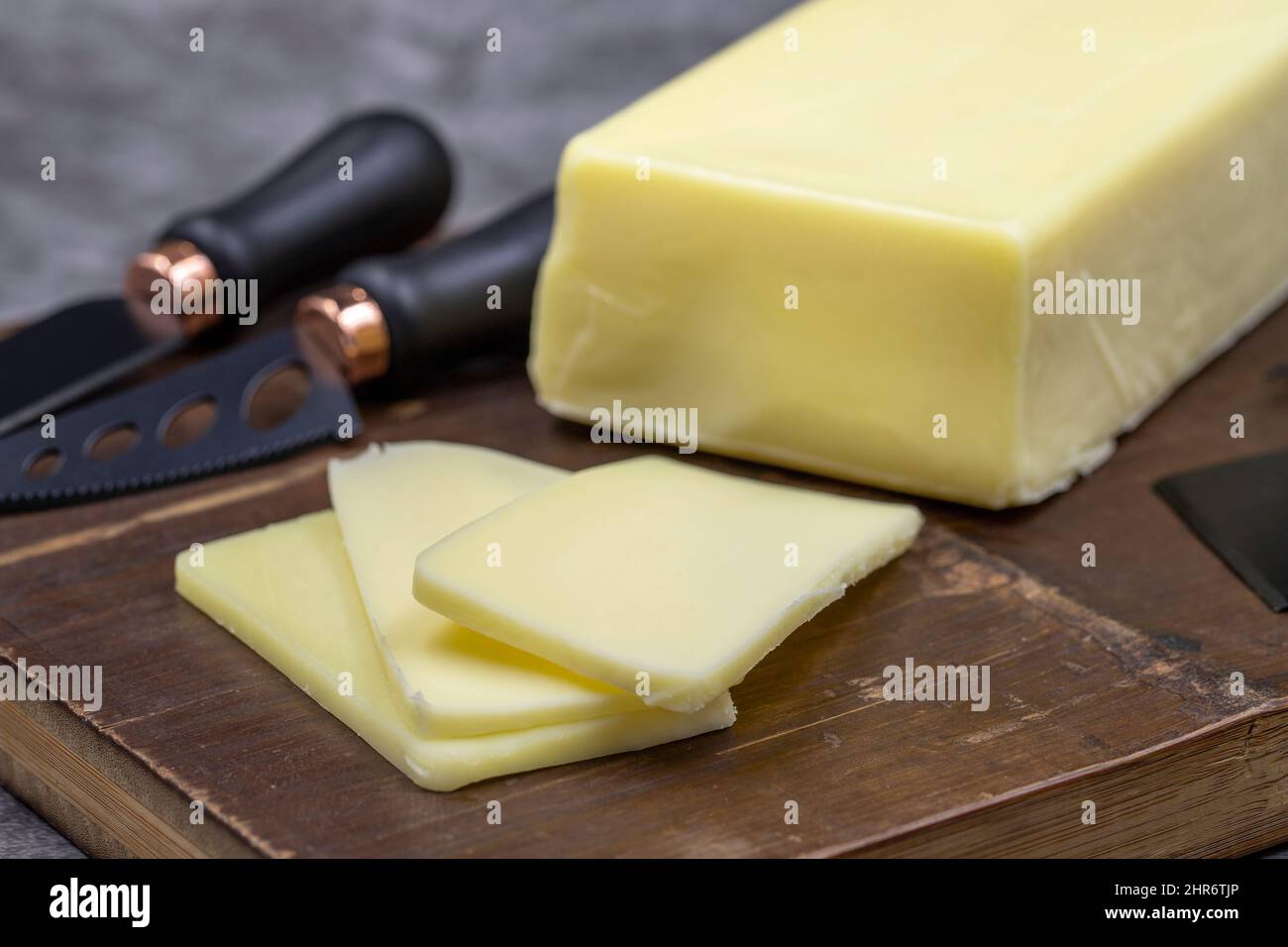 Kashar cheese or kashkaval cheese on dark background. Sliced Cheddar ...
