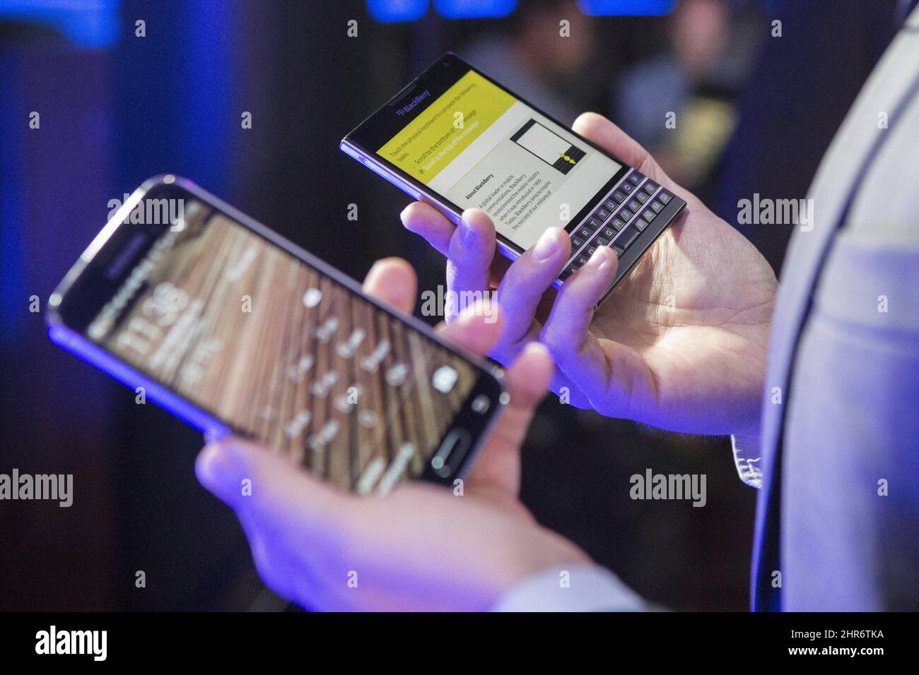 A journalist compares the new BlackBerry Passport device (right) to an ...
