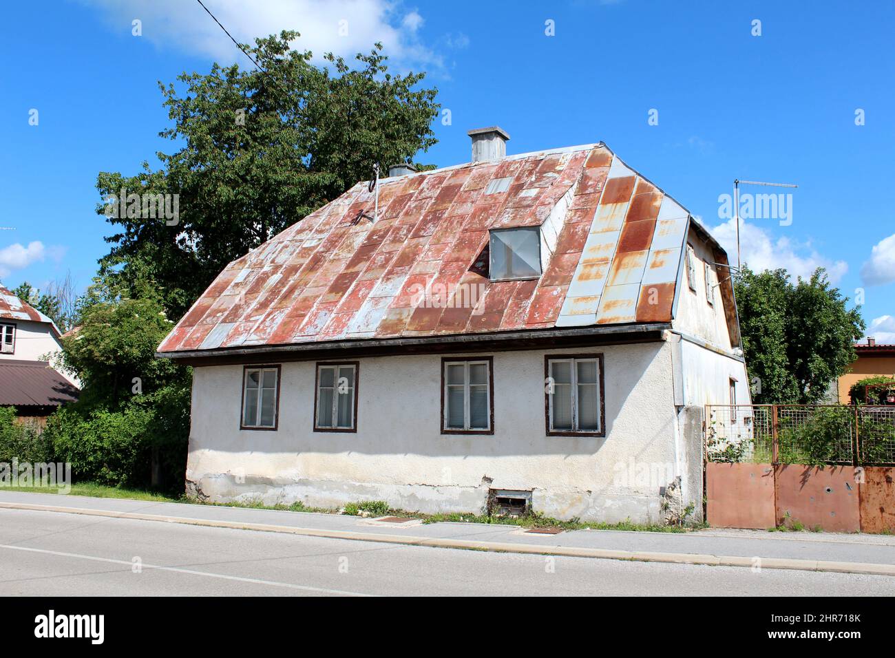 Traditional small old family house in rural area on concrete foundation with cracked facade ...