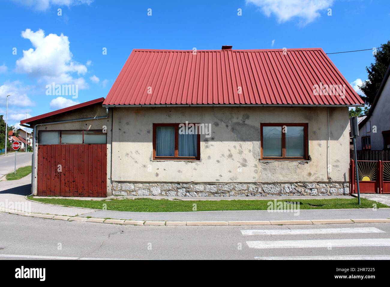 War damaged small suburban family house with still visible shrapnel holes in partially rusted ...