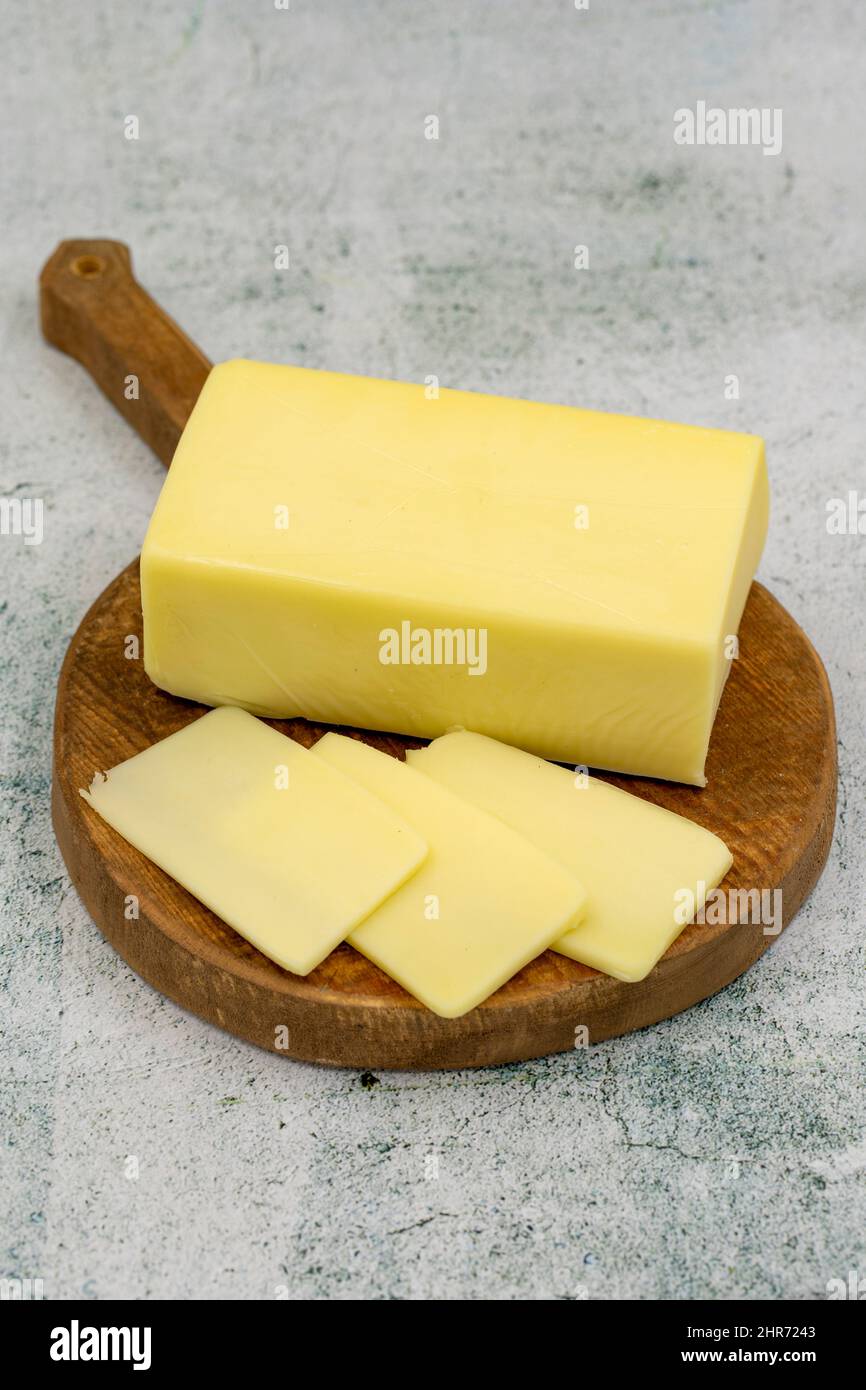 Kashar cheese or kashkaval cheese on stone background. Sliced Cheddar ...
