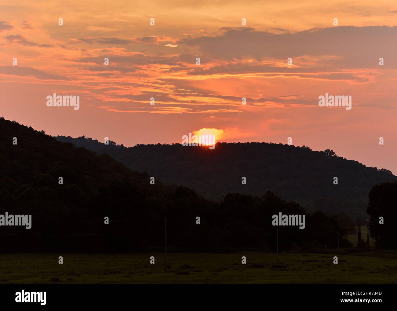 SUNSET BEHIND MOUNTAINS Stock Photo - Alamy