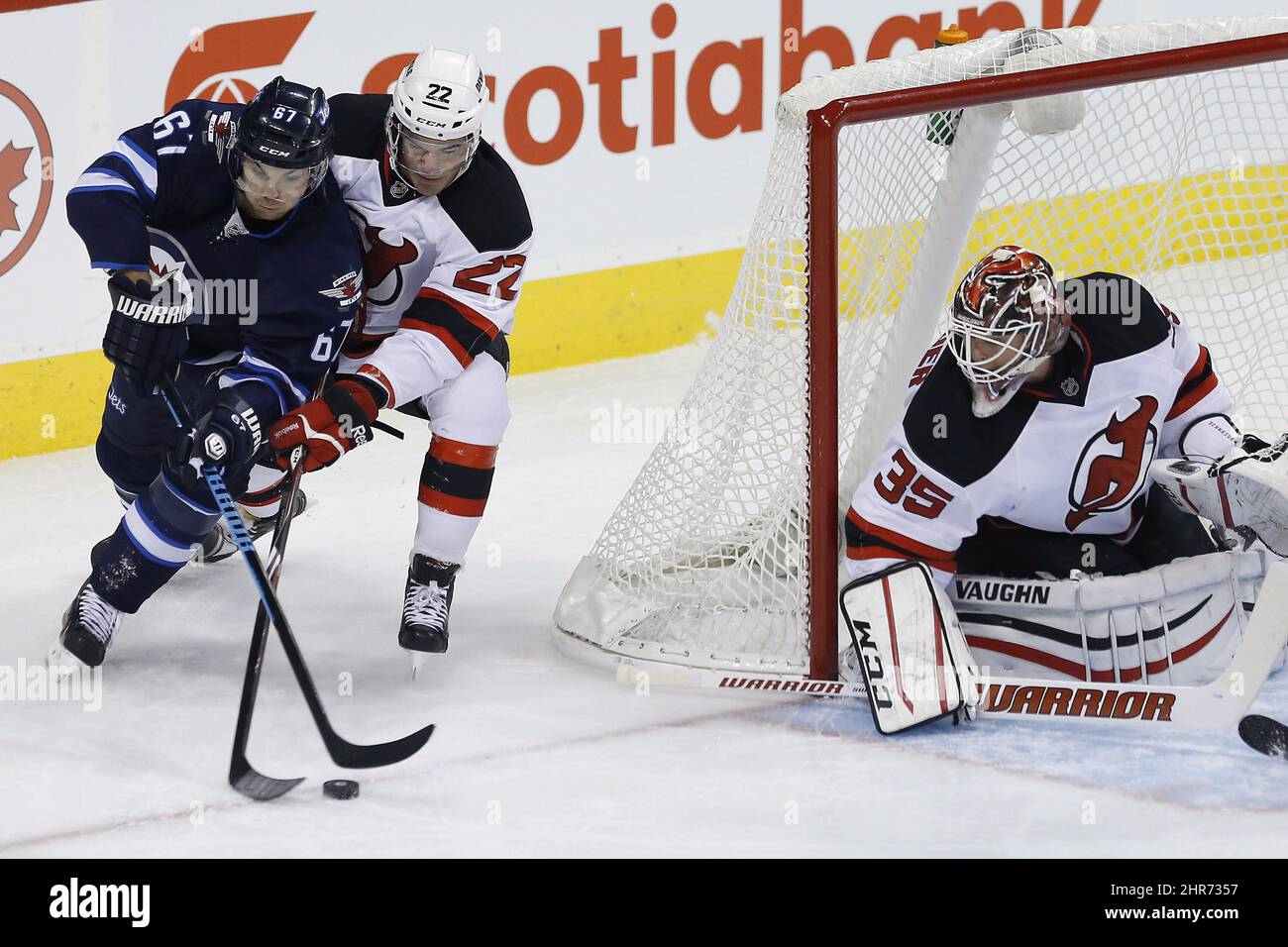 New Jersey Devils' Eric Gelinas (22) knocks the puck away from Winnipeg ...