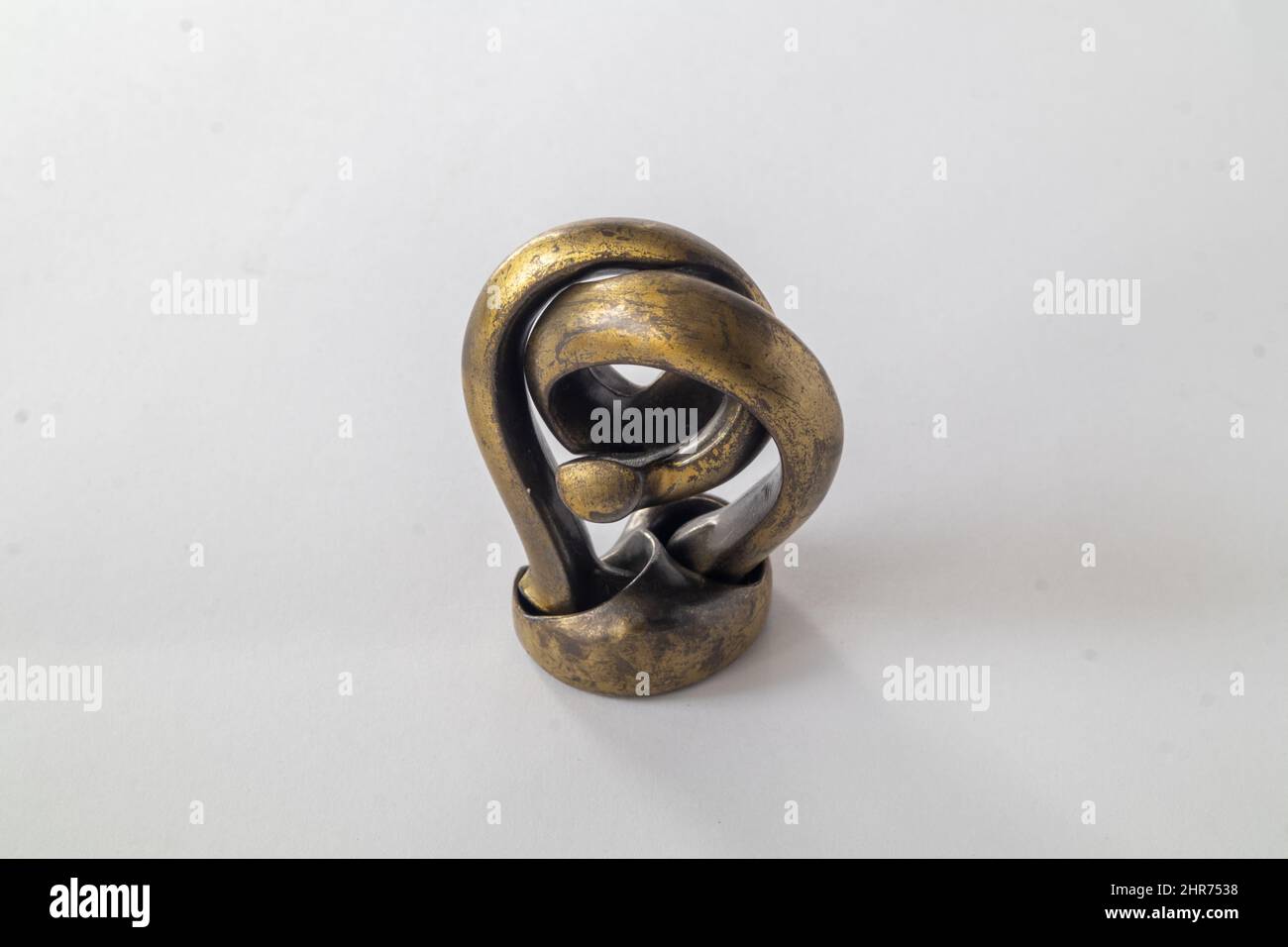 Metal yellow knot puzzle on a white background Stock Photo - Alamy