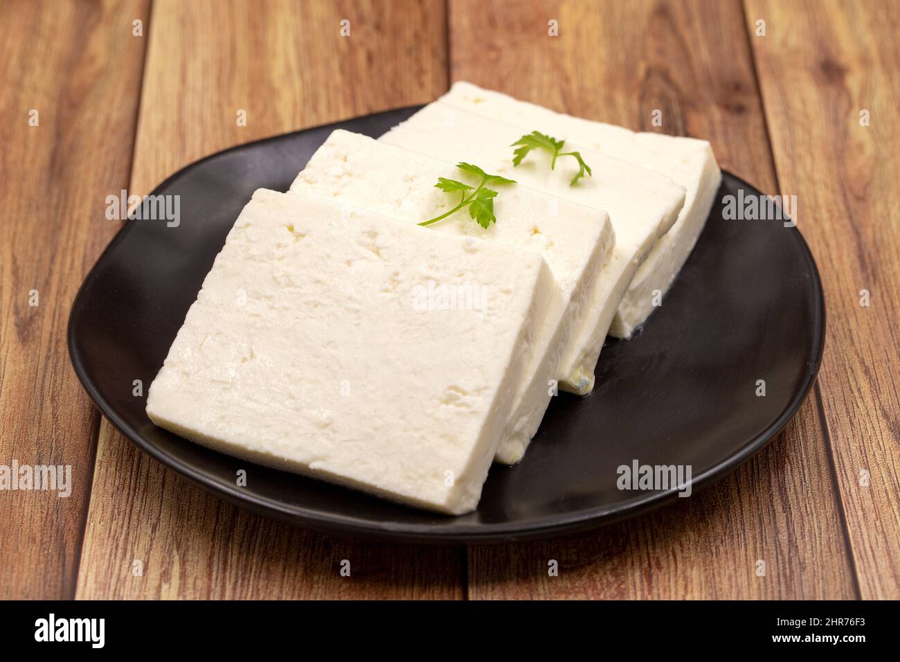 Sliced Feta cheese with herbs on wooden background. Close-up breakfast ...