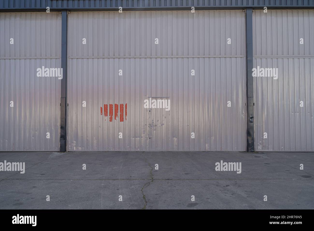 Large silver textured wall with a small orange design Stock Photo - Alamy