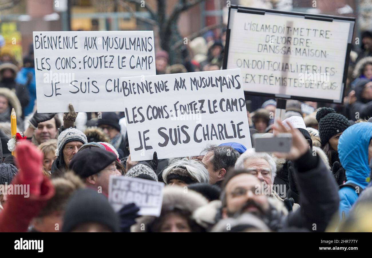 People hold up signs in Montreal, Sunday, January 11, 2015, during a ...