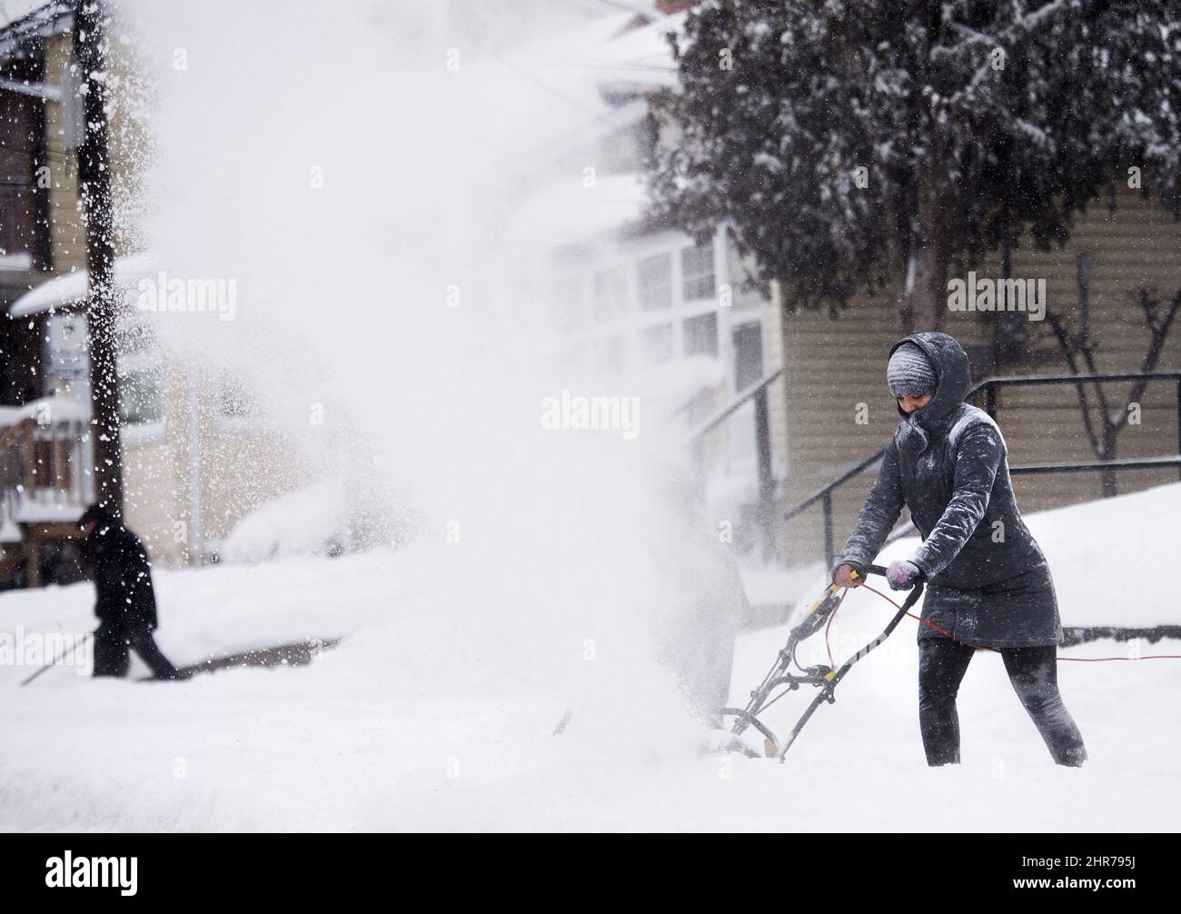 People clear snow from their sidewalks and streets after a large amount ...