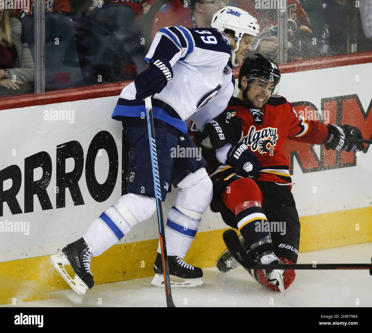 Winnipeg Jets Tobias Enstrom, left, from Sweden, checks Calgary Flames ...