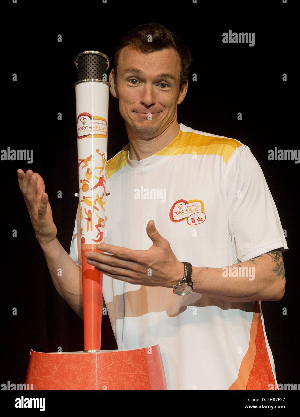 Olympian Simon Whitfield poses with the official Pan Am torch and ...