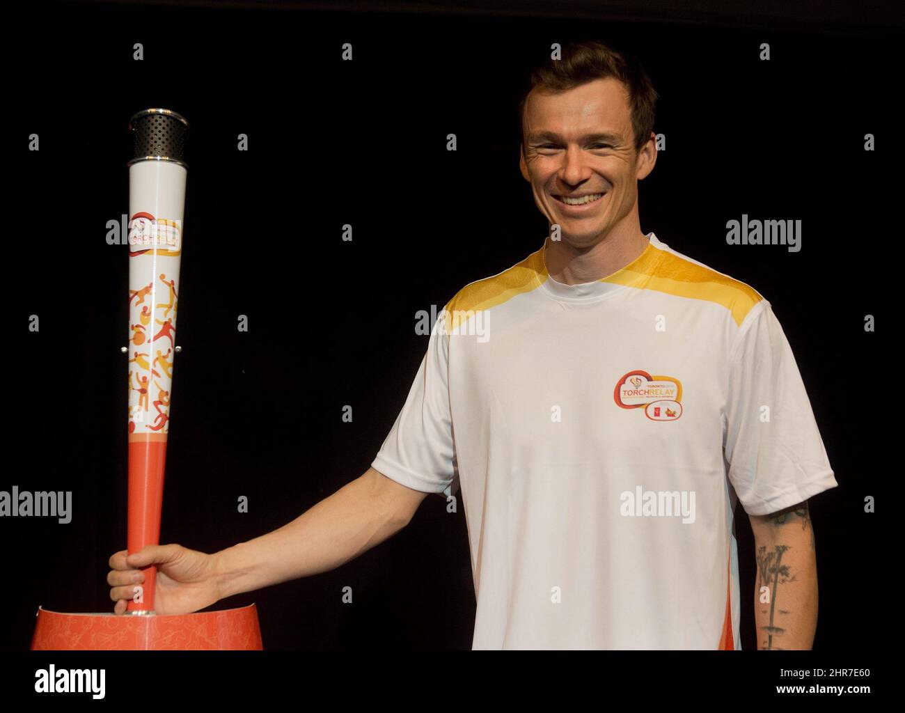 Olympian Simon Whitfield poses with the official Pan Am torch and ...