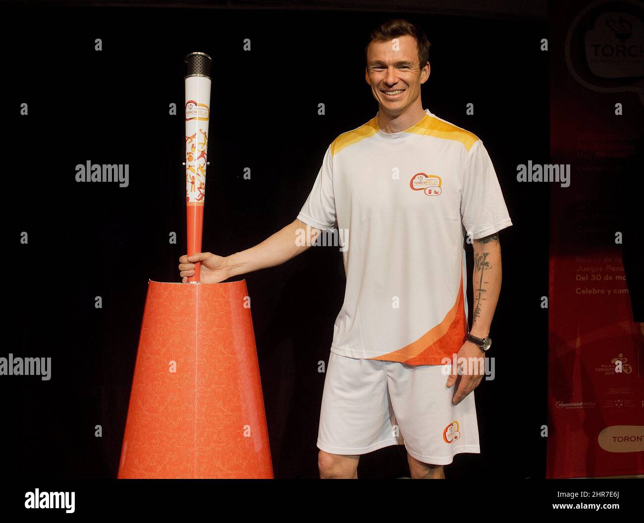 Olympian Simon Whitfield poses with the official Pan Am torch and ...