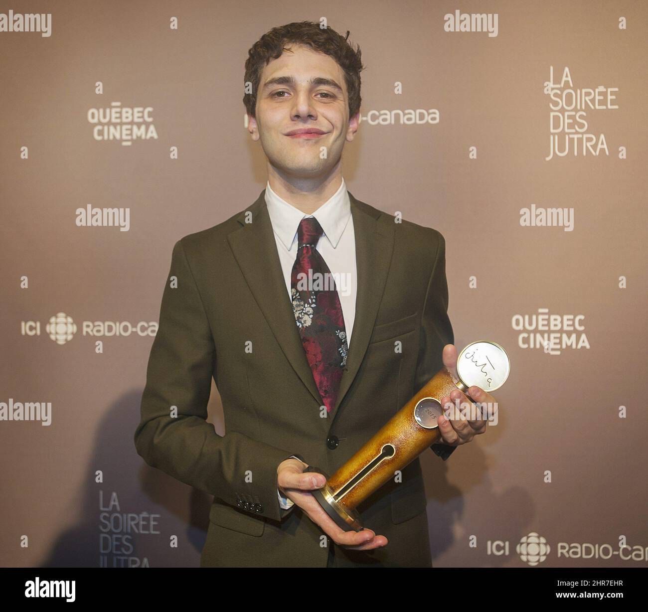 Xavier Dolan holds up his trophy for best director at the Jutra awards ...