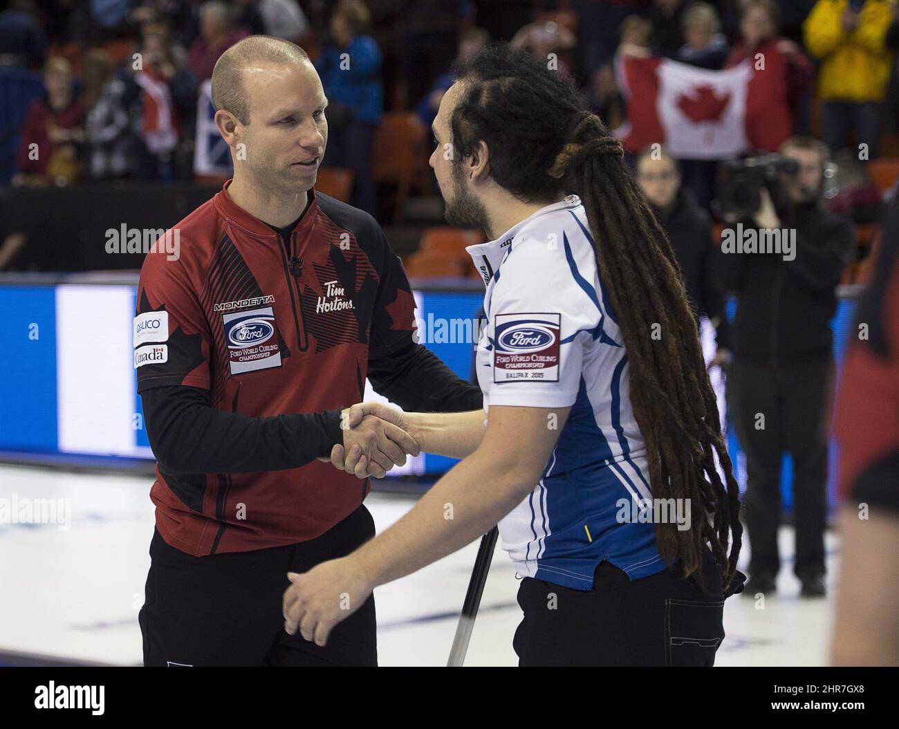 Team Canada skip Pat Simmons, left, shakes hands with Finland's Pauli ...