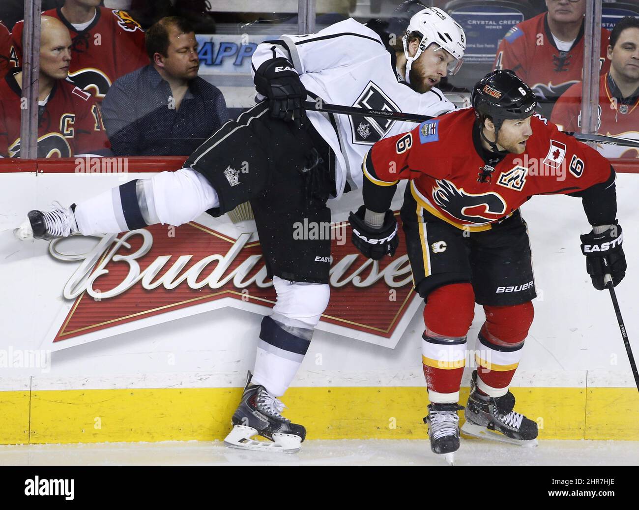 Los Angeles Kings' Jake Muzzin, left, is hit by Calgary Flames' Dennis ...