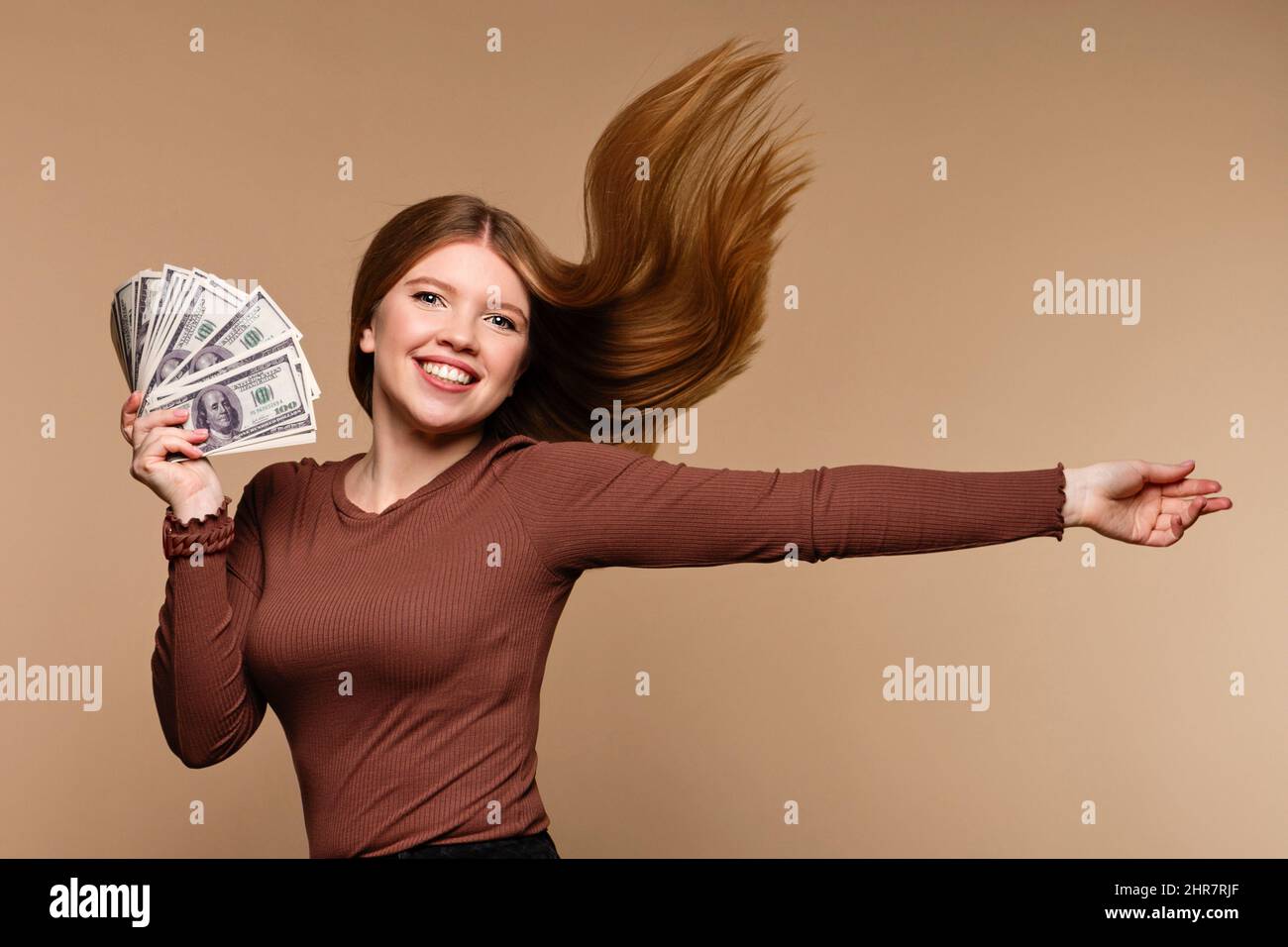 Wide smiling woman with dollar fan and flowing hair. Healthy hair expensive care. Wealth and ...