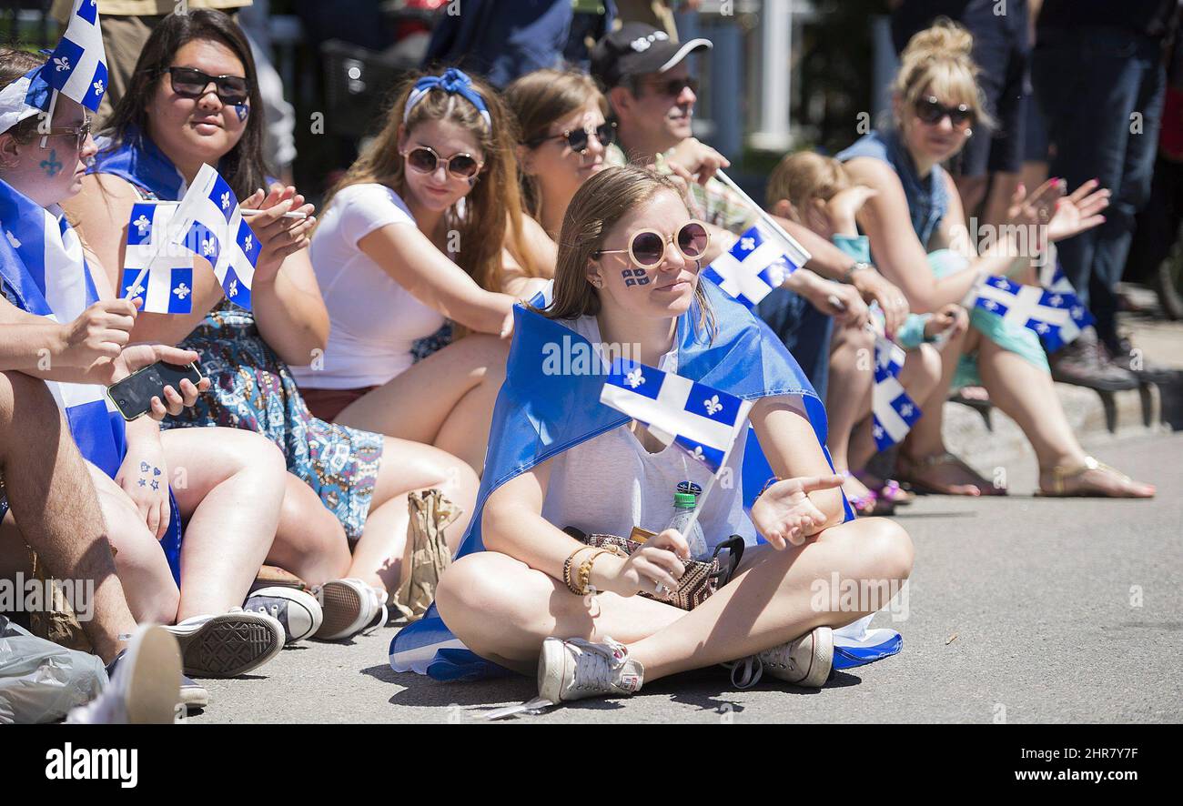 Members of the the crowd watch the annual St-Jean-Baptiste Day parade ...
