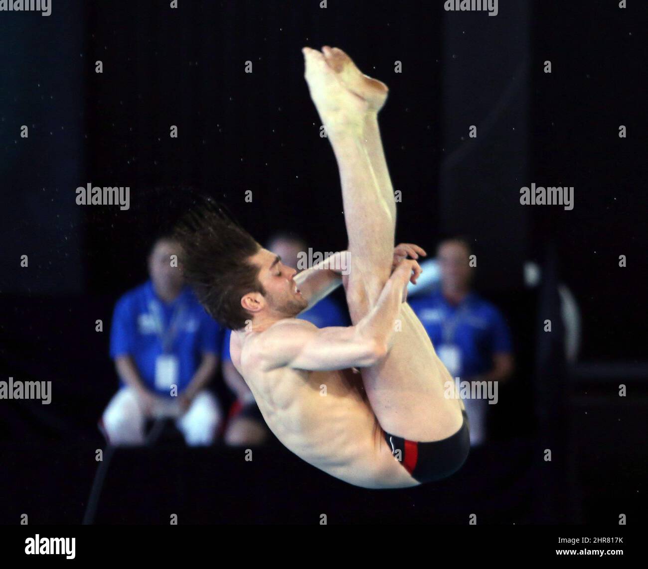 Maxim Bouchard of Canada dives as judges look on during the men's 10m ...