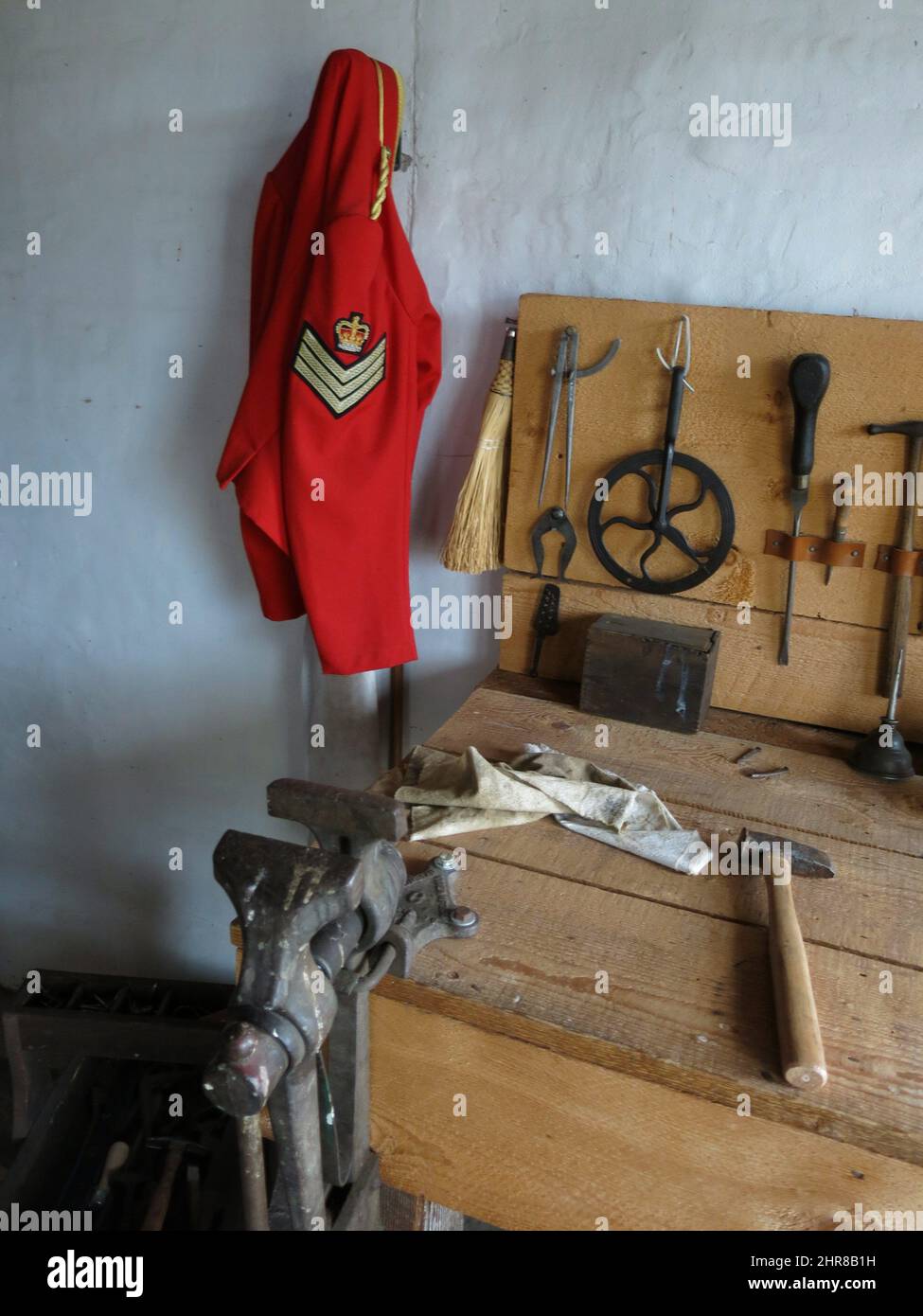 A red serge jacket hangs next to a bench in the blacksmith's shop at a ...