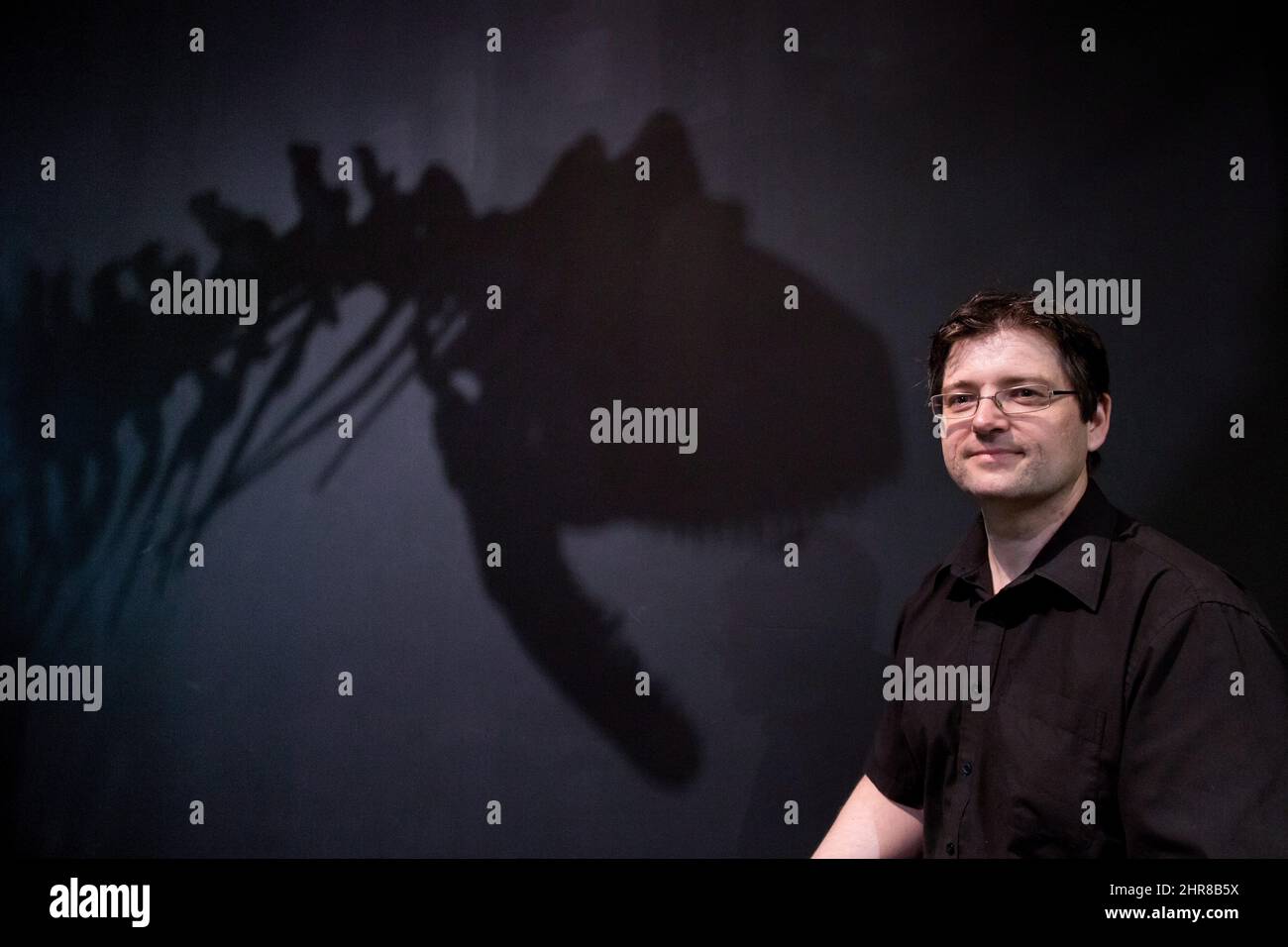 A shadow of a dinosaur skeleton falls on a wall as natural history ...
