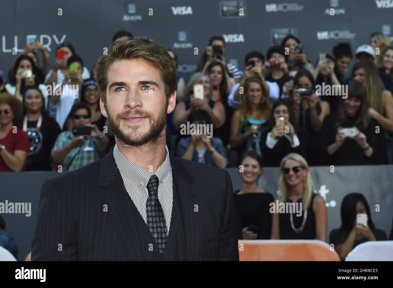 Actor Liam Hemsworth poses for photographs as she arrives on the red ...