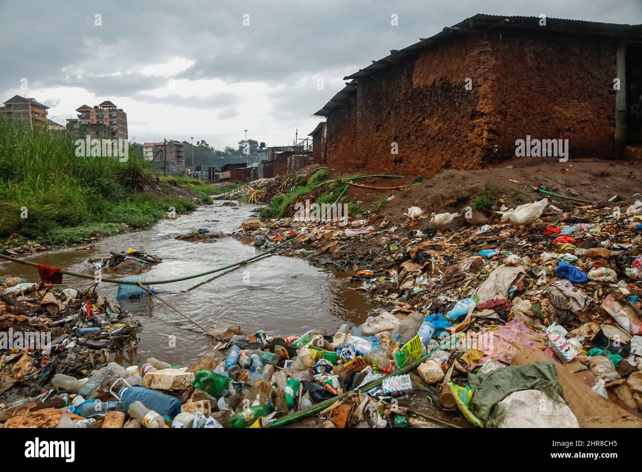 A river chocked with plastics and human waste runs alongside the houses ...