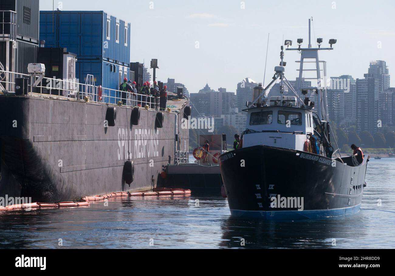 Workers stand on a spill response tank barge during a Western Canada ...