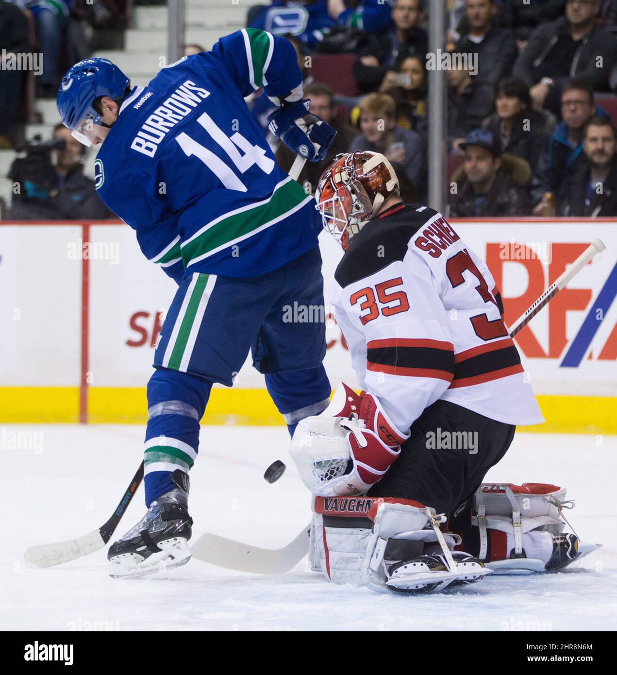 New Jersey Devils' goalie Cory Schneider, right, makes the save while ...