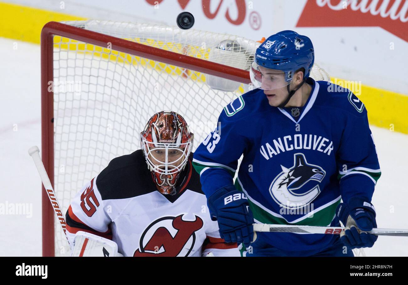 A shot sails over New Jersey Devils' goalie Cory Schneider, left, and ...