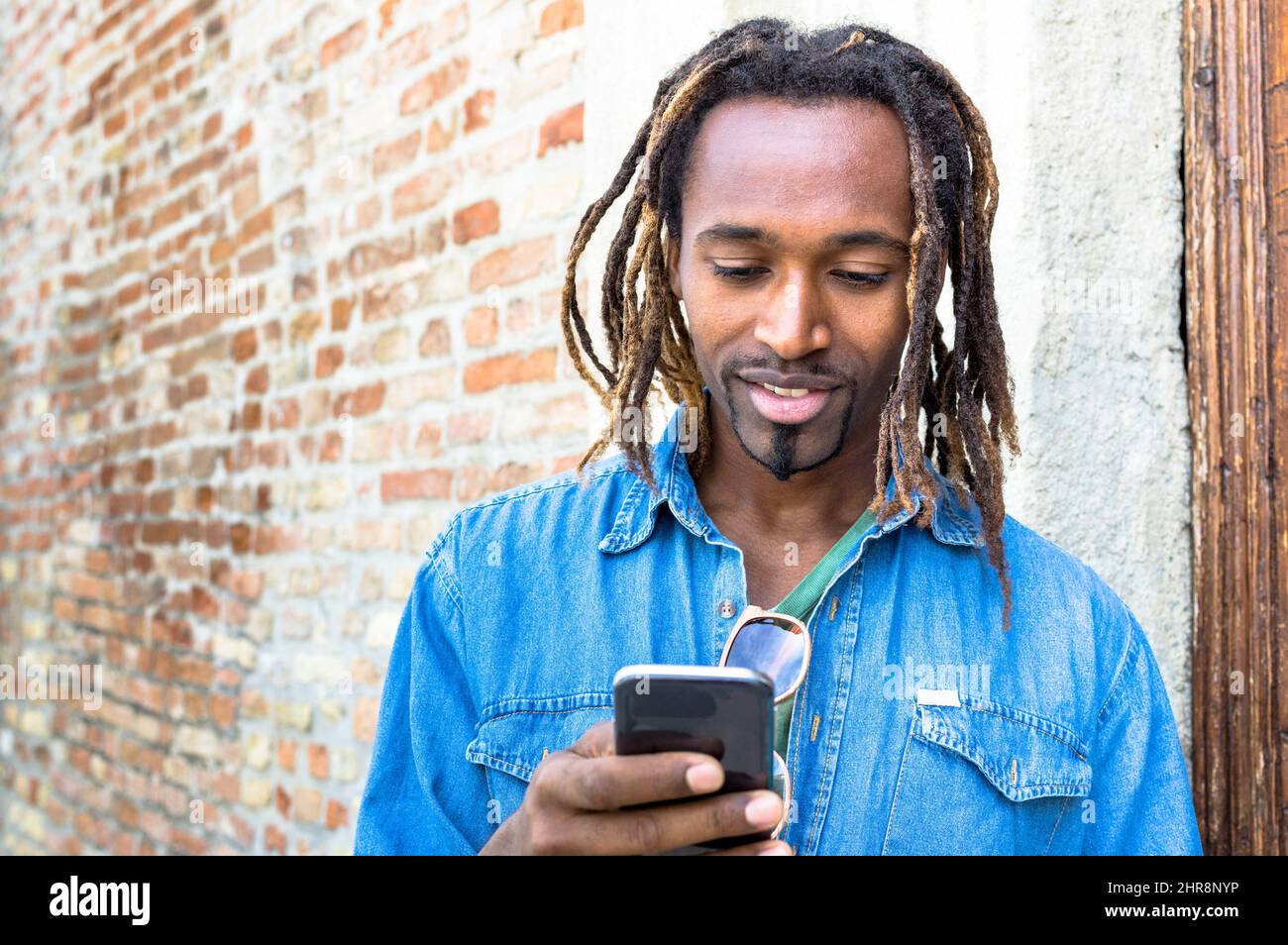 African american young man using mobile smart phone - Hipster guy model ...