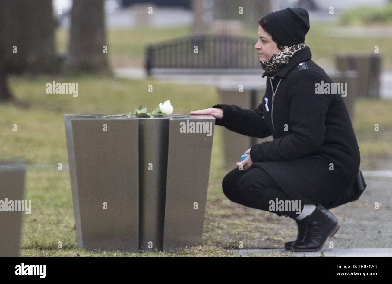 A woman places her hand on a memorial to one of the fourteen women ...