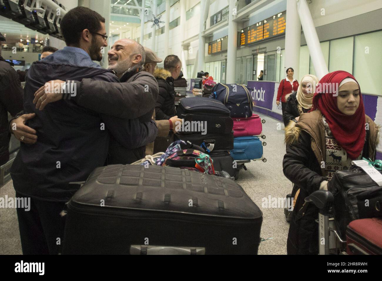 Mazan Khabbaz, centre left, a refugee from Syria, is embraced by a well ...
