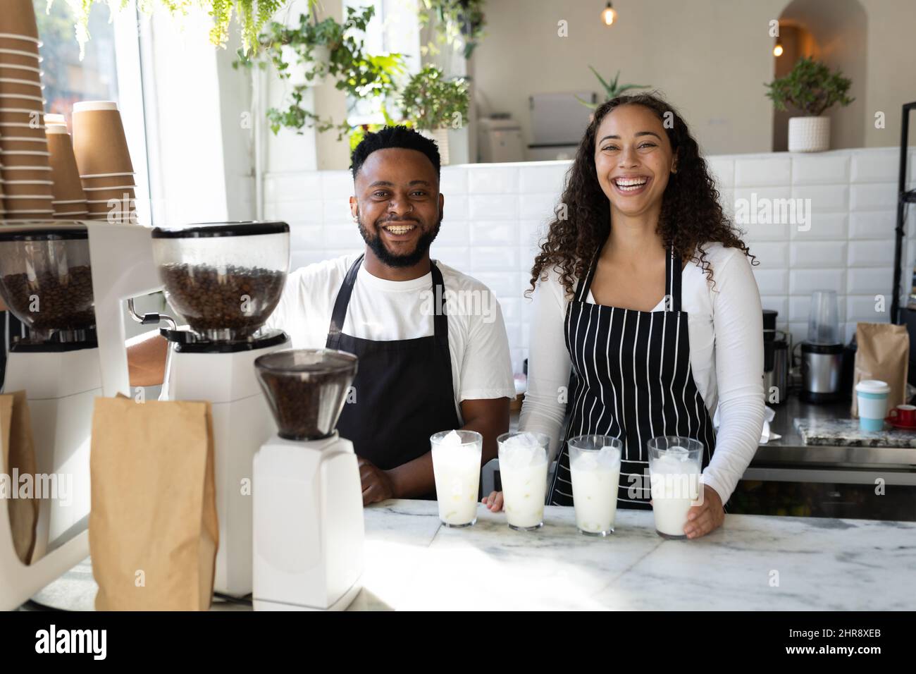 Portrait of cheerful african american baristas making iced coffee at ...
