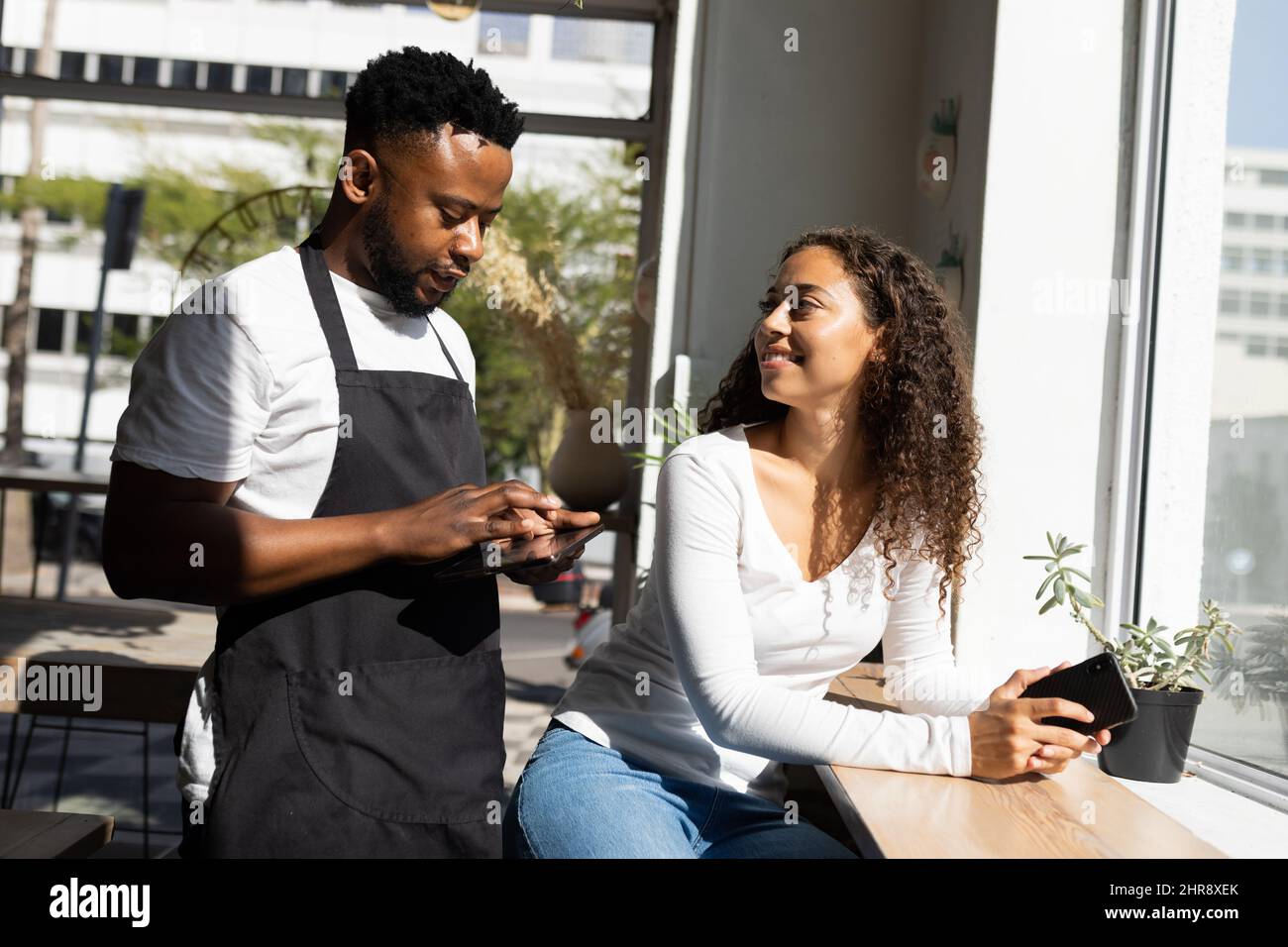 African american barista taking order from female customer in tablet at ...