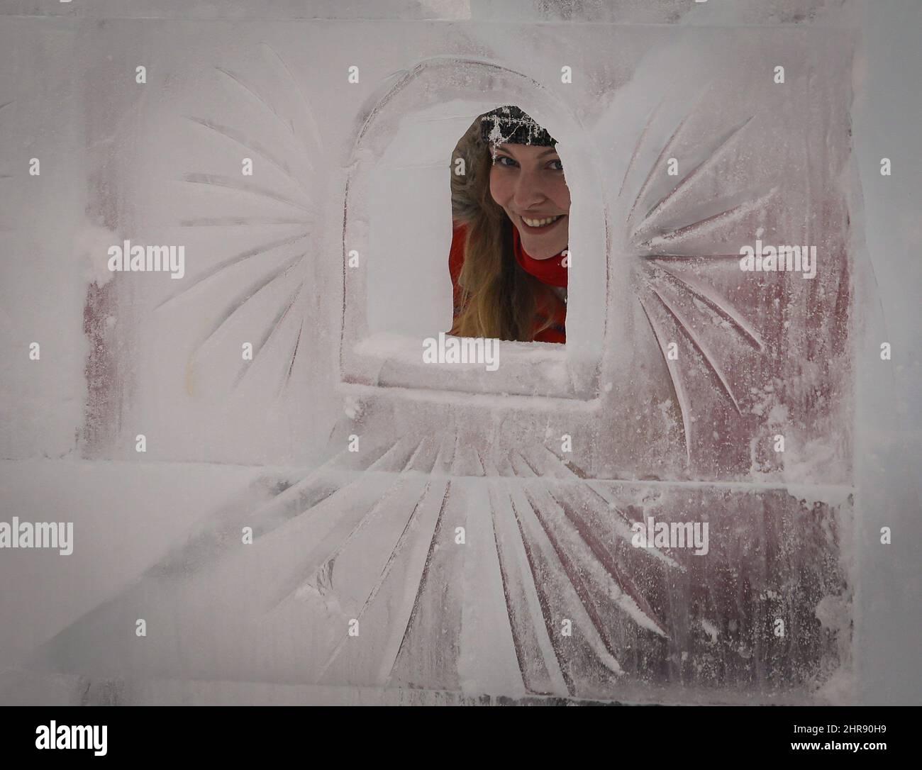 A tourist peers out form the window of an ice castle as she takes in ...