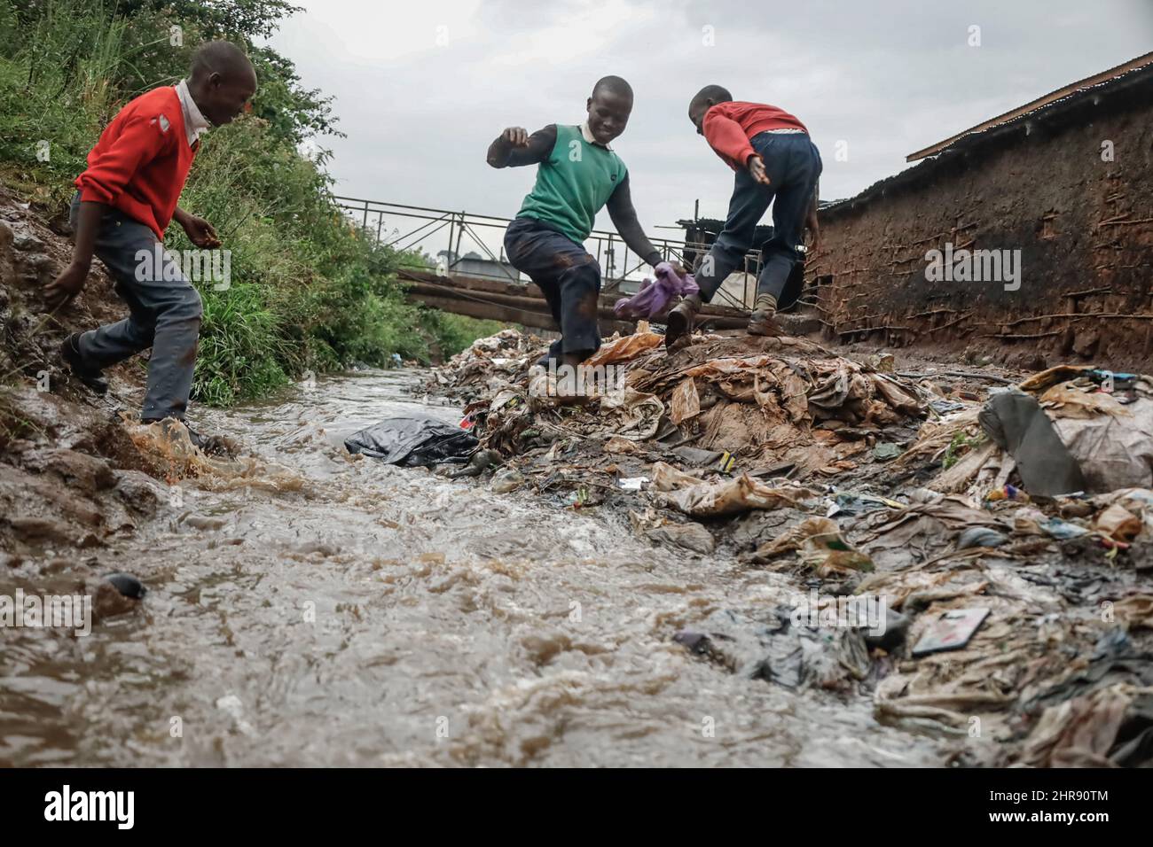 Pupils jump through a local river chocked with plastics and human waste ...