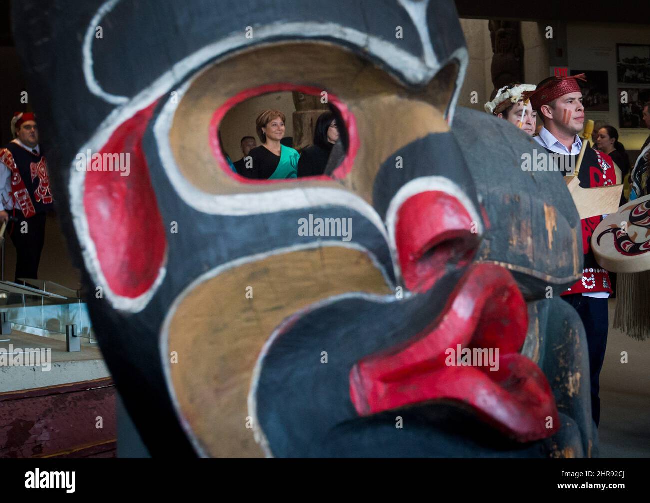 B.C. Premier Christy Clark, left, is framed by a First Nations carving ...
