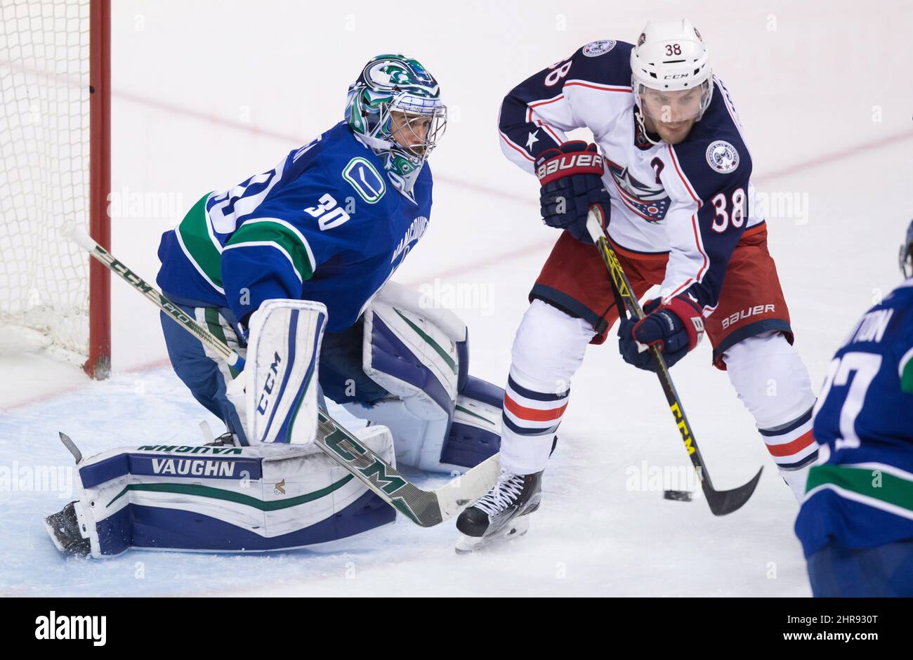 Columbus Blue Jackets' Boone Jenner, right, tries to redirect the puck ...