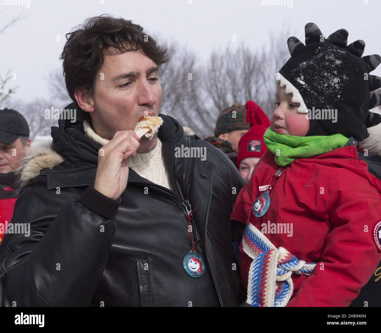 Prime Minister Justin Trudeau samples maple taffy while holding his son ...