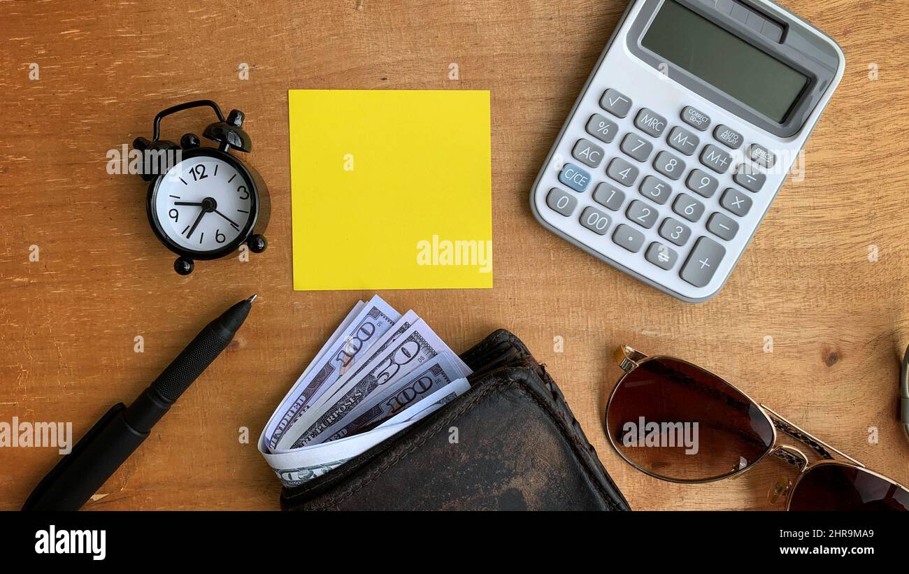 Top view of wallet, bank notes, alarm clock, glasses, calculator and ...