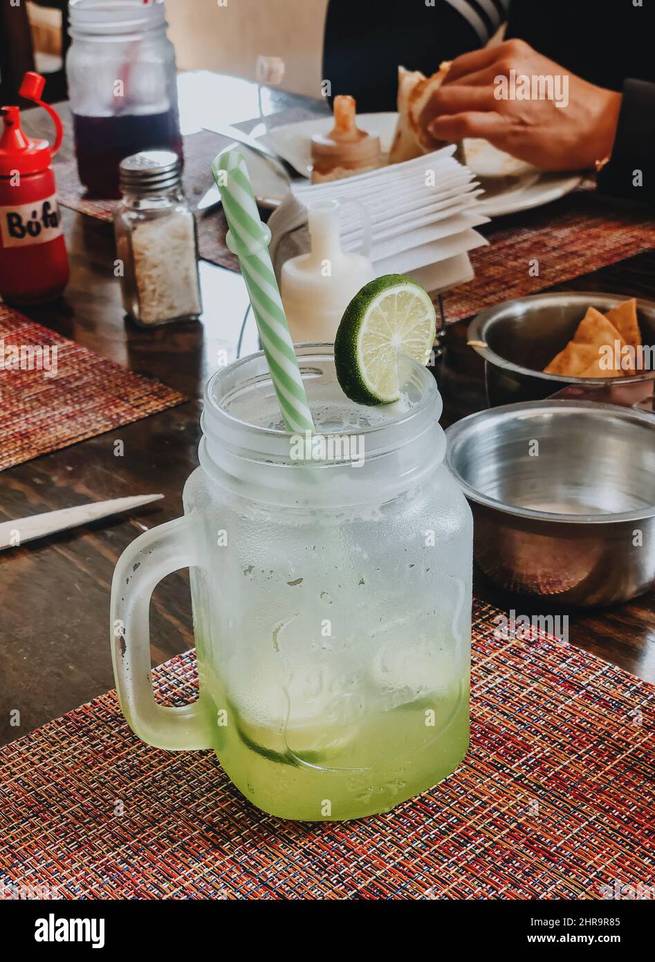 Close-up shot of a Lemon juice in a jar mug with lemon slice and straw ...